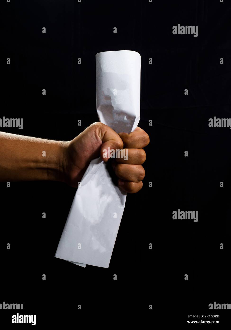 Man hand holding and squizing a white paper, isolated on black Stock ...
