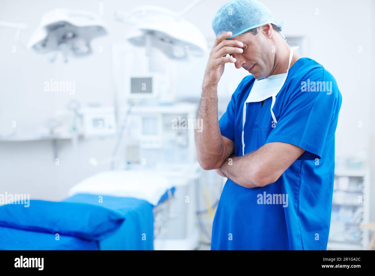 Taking a minute to myself. A doctor holding his hand over his face ...