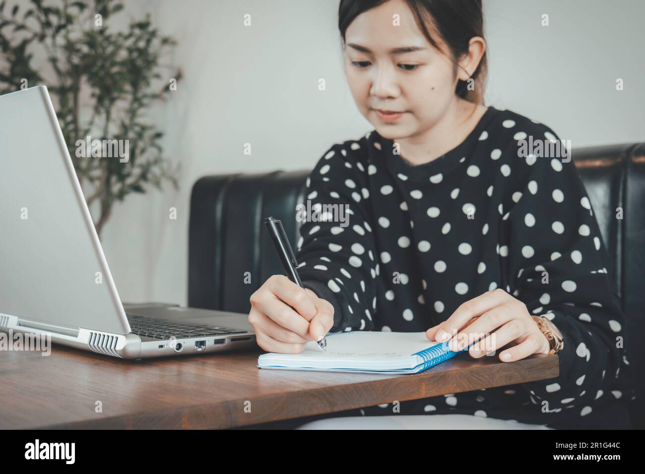 Young asian woman pupil writing notes in notebook at work table ...