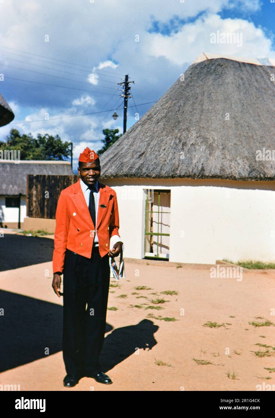 African man, wearing a red uniform, possibly in the hospitality ...