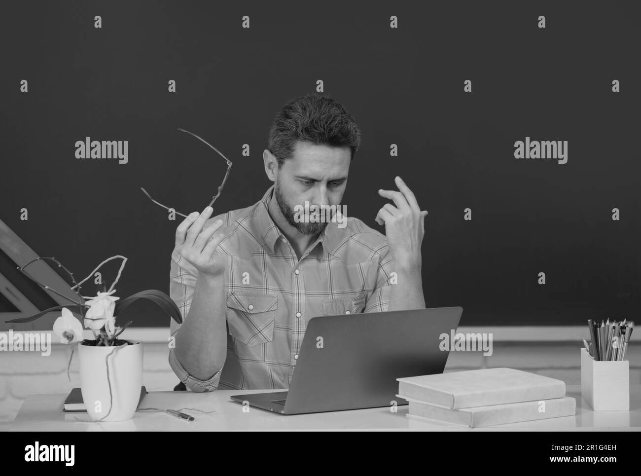 Man teacher. Portrait of smart young tutor in glasses with book on the ...