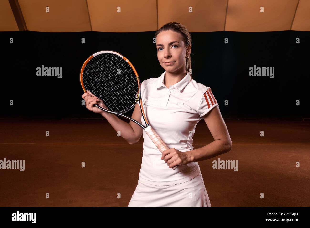 Sportswoman at the tennis court with racquet Stock Photo - Alamy