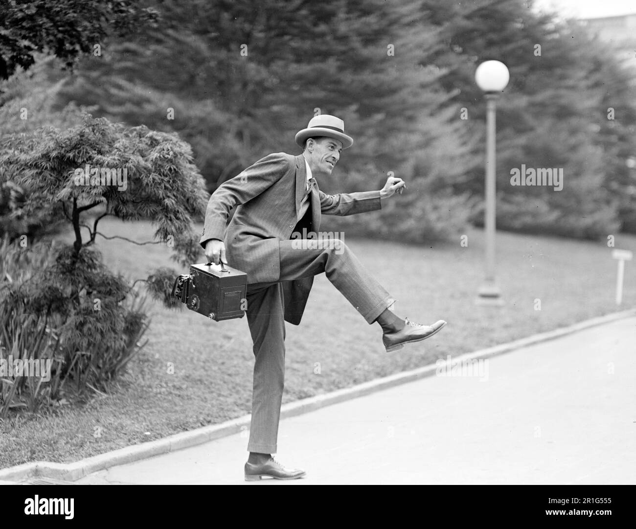 Archival Photo: Photographer holding a camera kicking or dancing ...