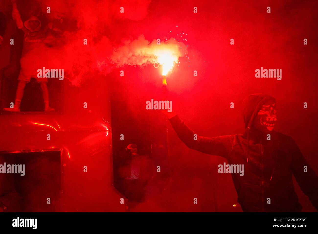 A football fan with a fire flare in his hands during a football parade ...