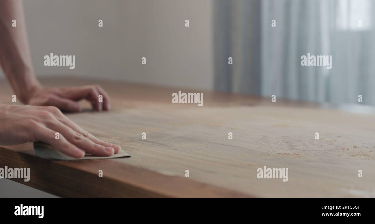 man hand sanding black walnut wood table, wide photo Stock Photo - Alamy