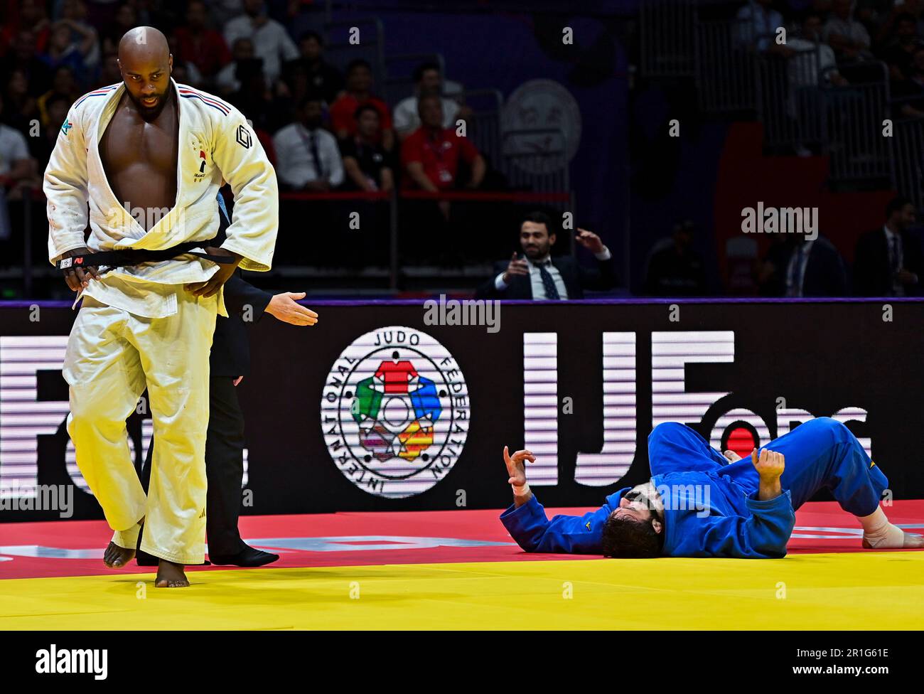 Doha. 13th May, 2023. Teddy Riner (L) of France reacts after winning the men's 100kg gold medal ...