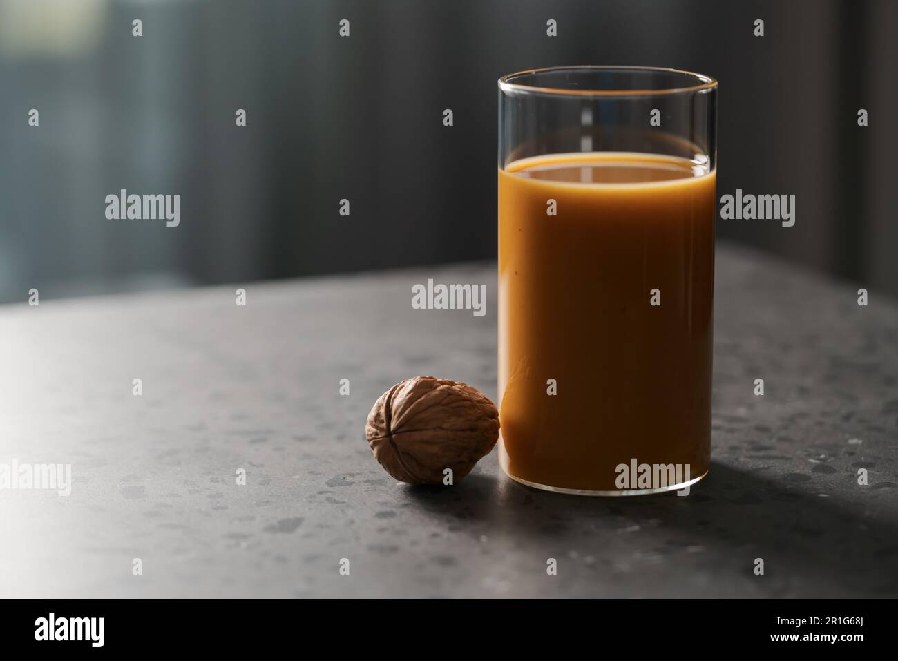 Pumpkin kuice in glass on concrete countertop with copy space, shallow ...
