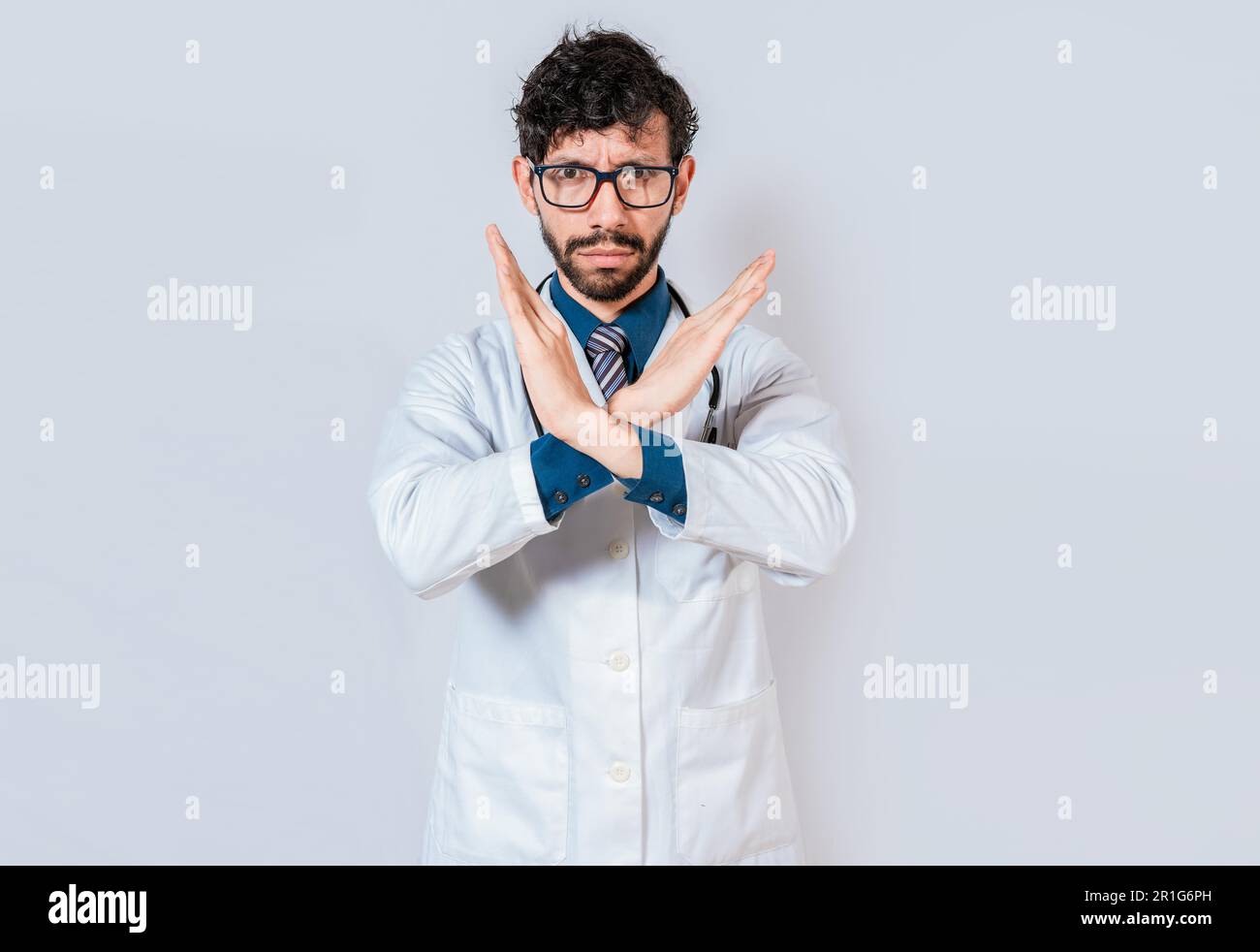 Young doctor making stop sign with hands isolated. Doctor making a stop ...