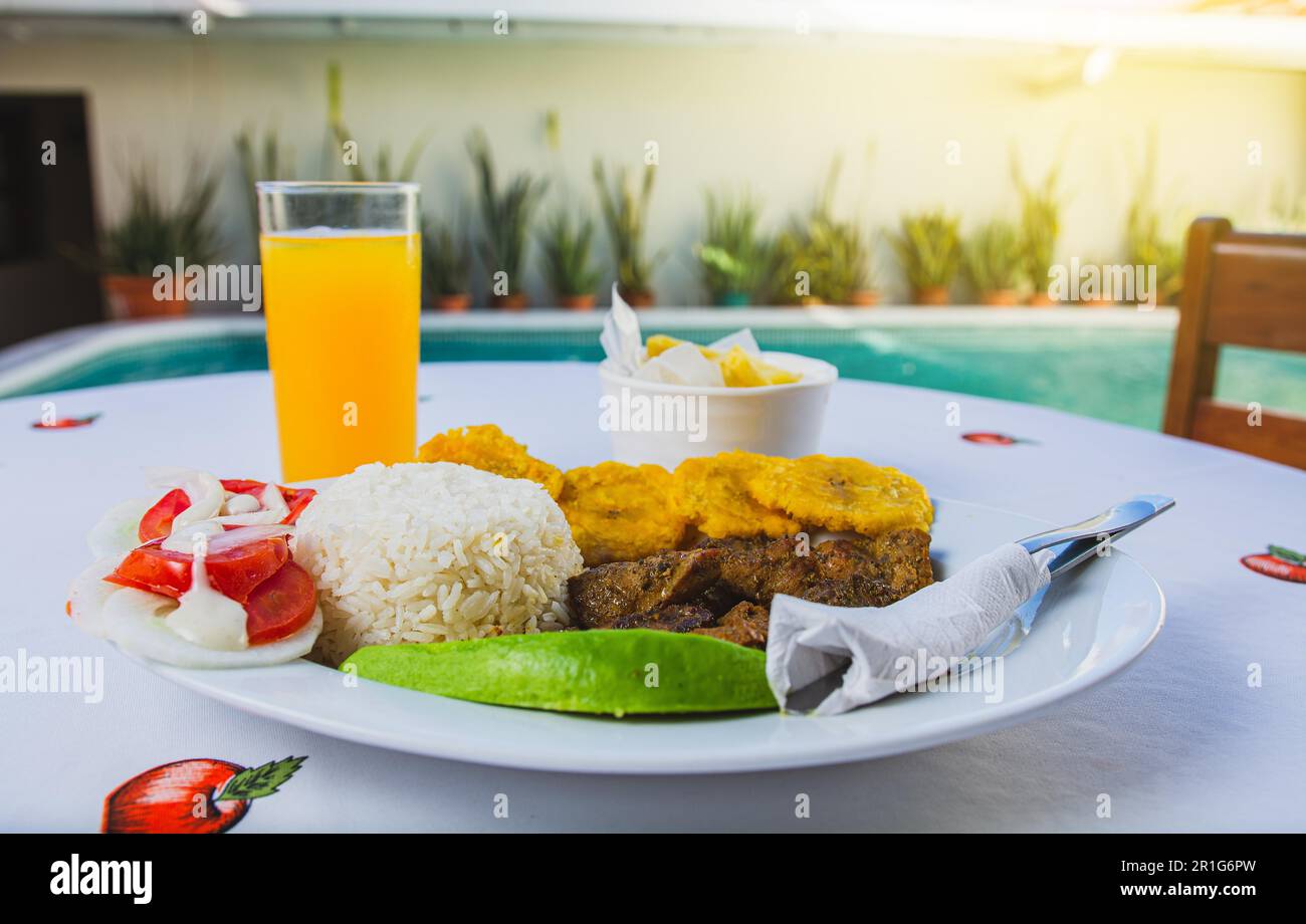 Traditional breakfast with orange juice near a swimming pool. Vacation ...