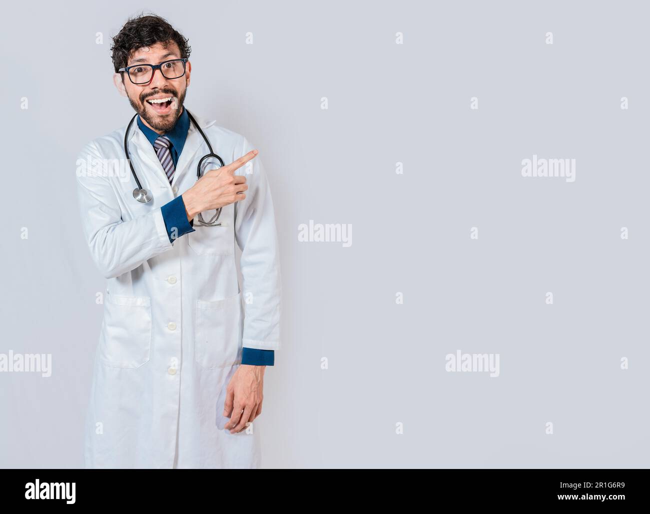 Young doctor pointing a promotion with finger. Happy doctor pointing at ...