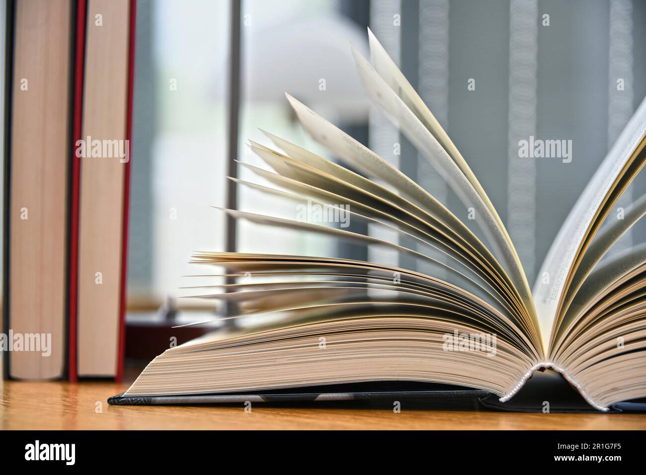 Hardcover book lying on the table in a library Stock Photo - Alamy