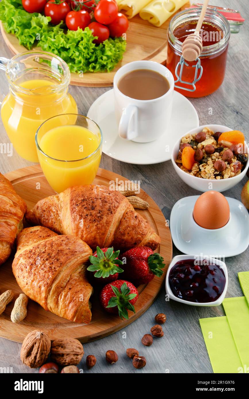 Breakfast consisting of croissants, coffee, fruits, orange juice and ...