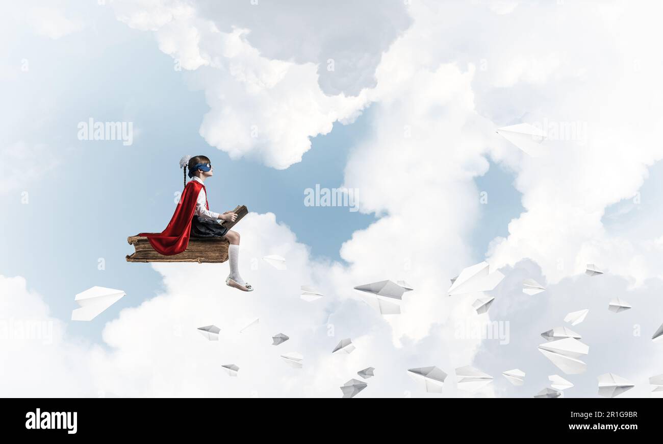 Girl power concept with cute kid guardian against cloudscape background ...