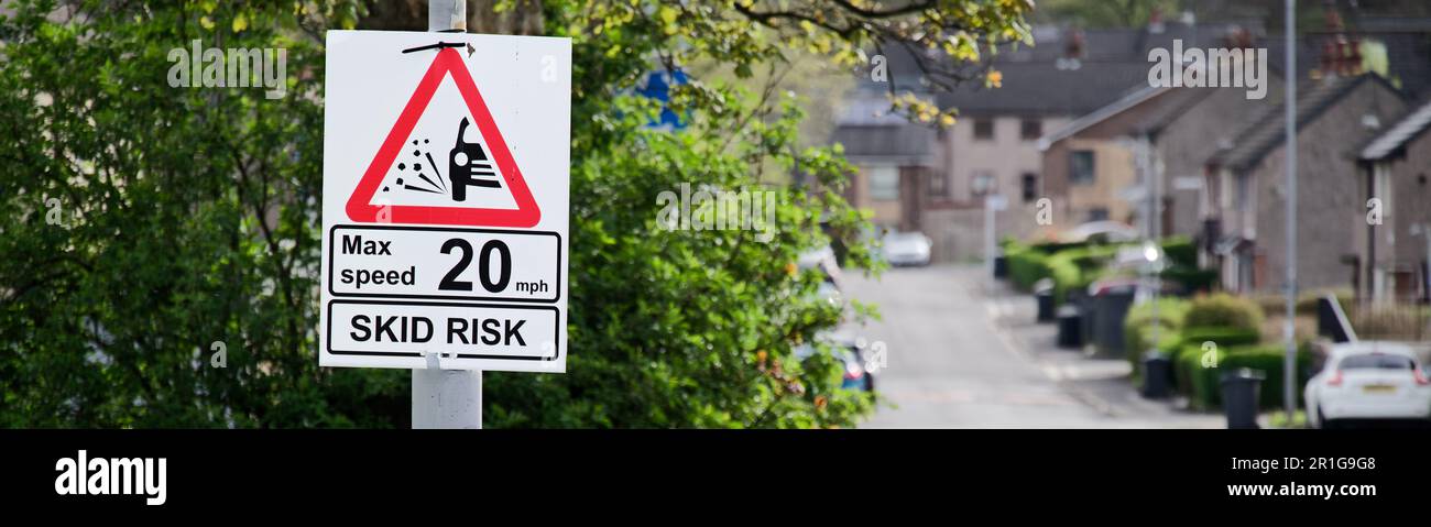 Skid risk road speed limit safety sign Stock Photo - Alamy