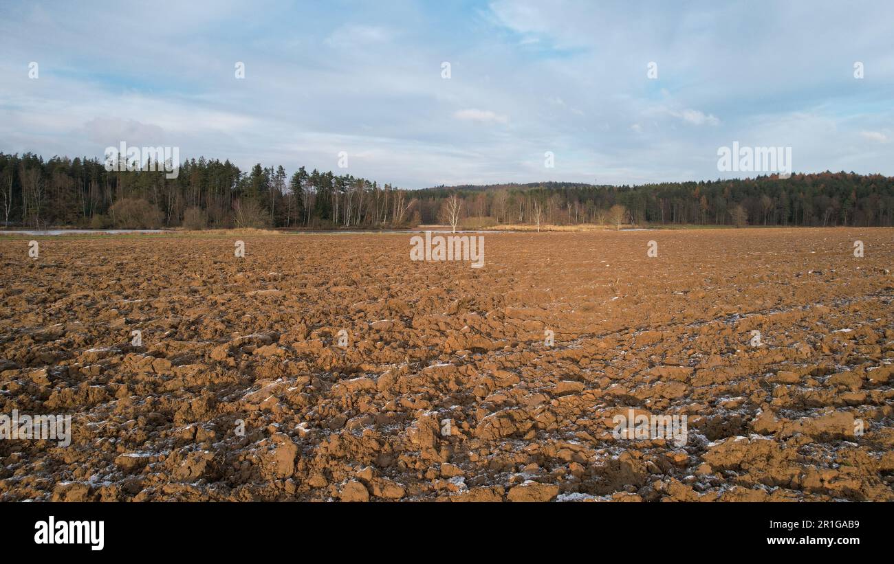 A scenic landscape featuring an expansive field surrounded by large ...