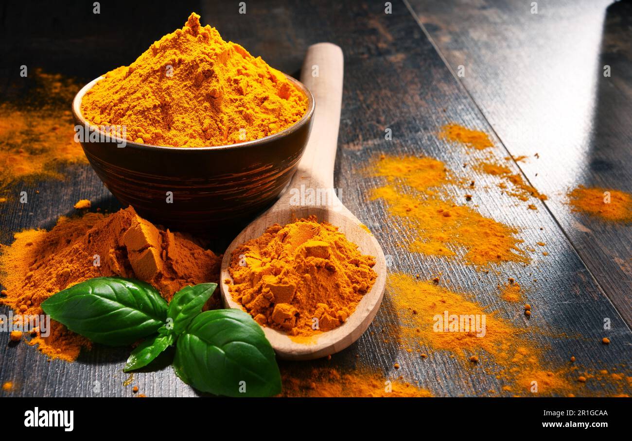 Composition with bowl of turmeric powder on wooden table Stock Photo ...