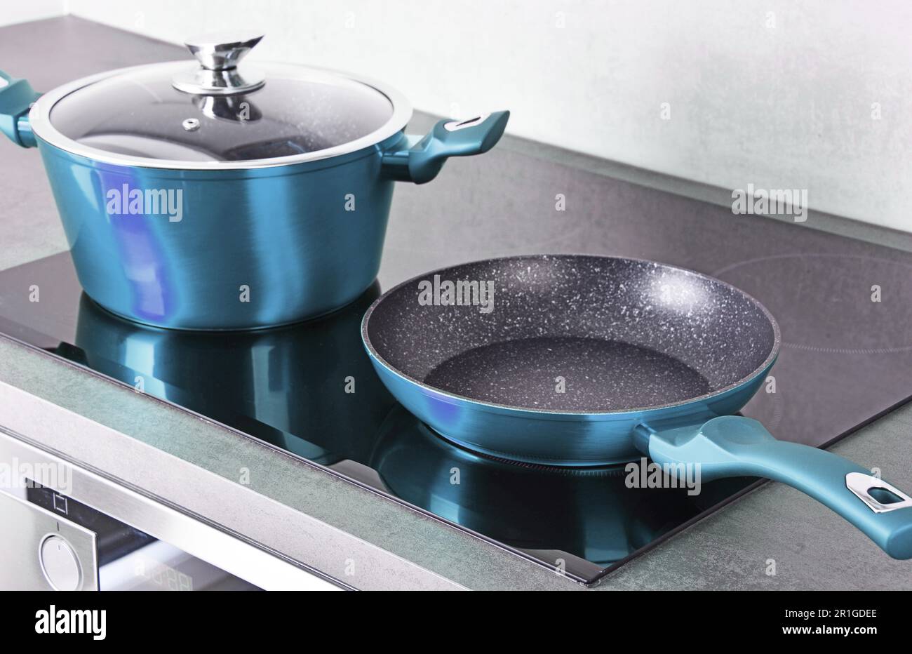 Frying pan and steel pot on modern induction cooktop Stock Photo - Alamy