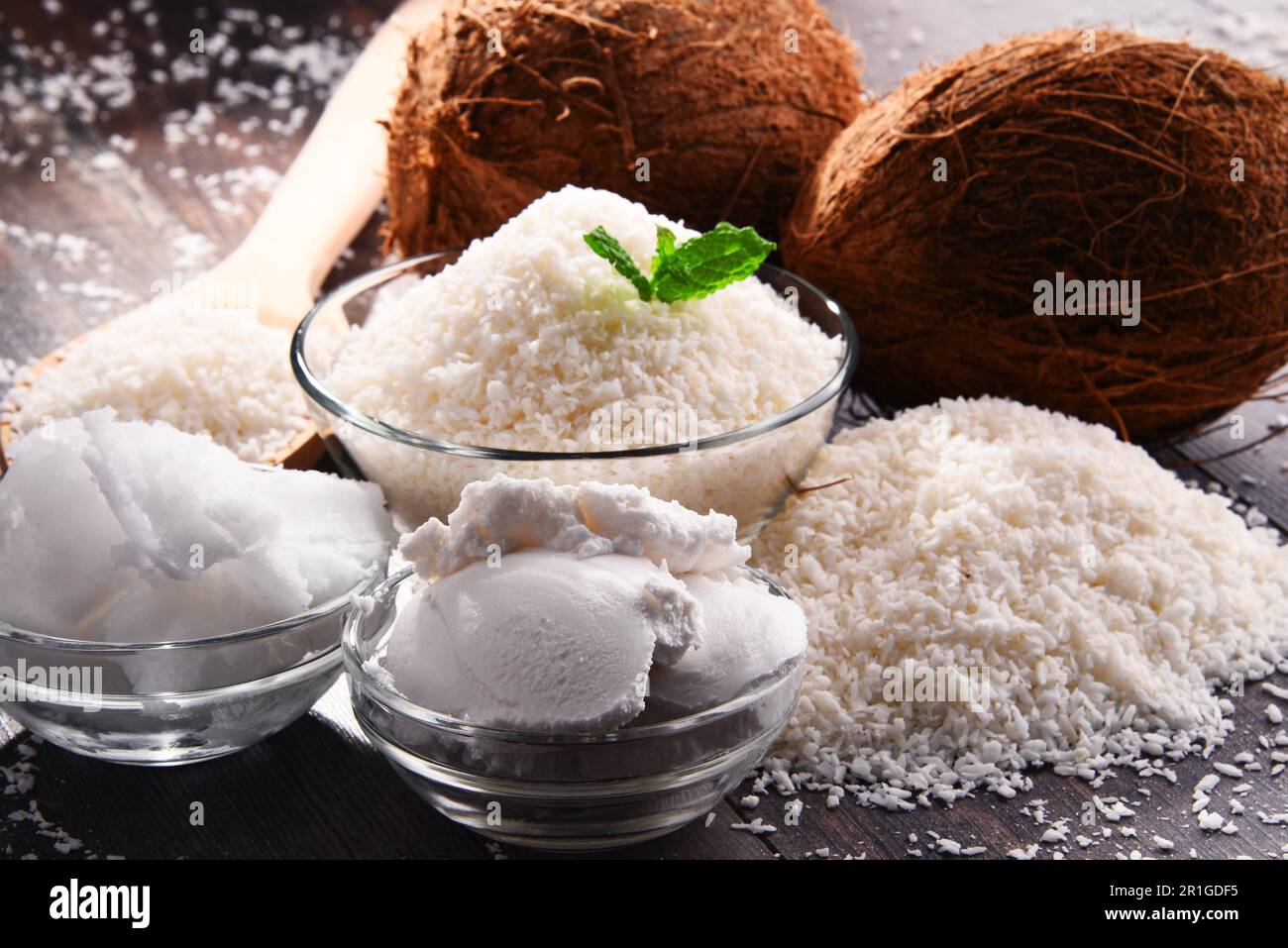 Composition with bowl of shredded coconut and shells on wooden table ...