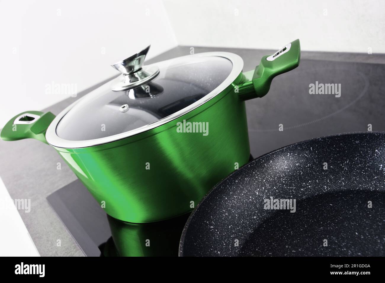 Frying pan and steel pot on modern induction cooktop Stock Photo - Alamy