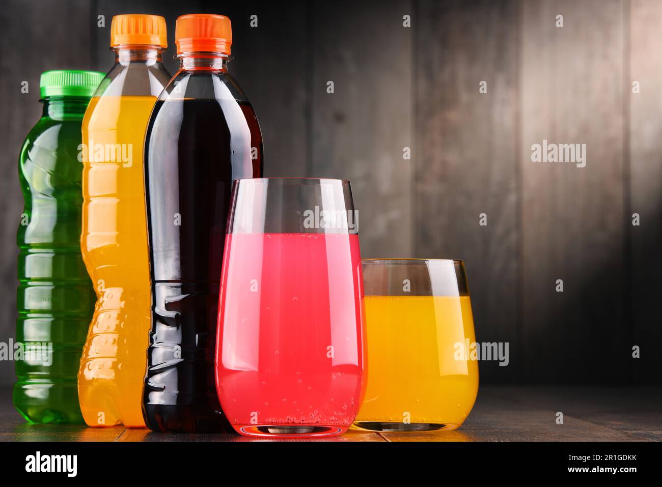 Glasses and bottles of assorted carbonated soft drinks in variety of ...