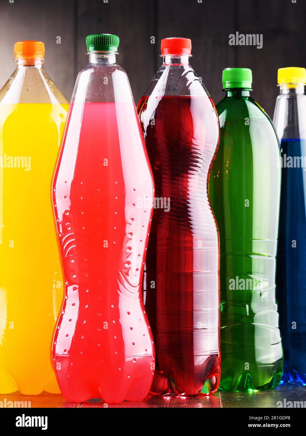 Plastic bottles of assorted carbonated soft drinks in variety of colors ...