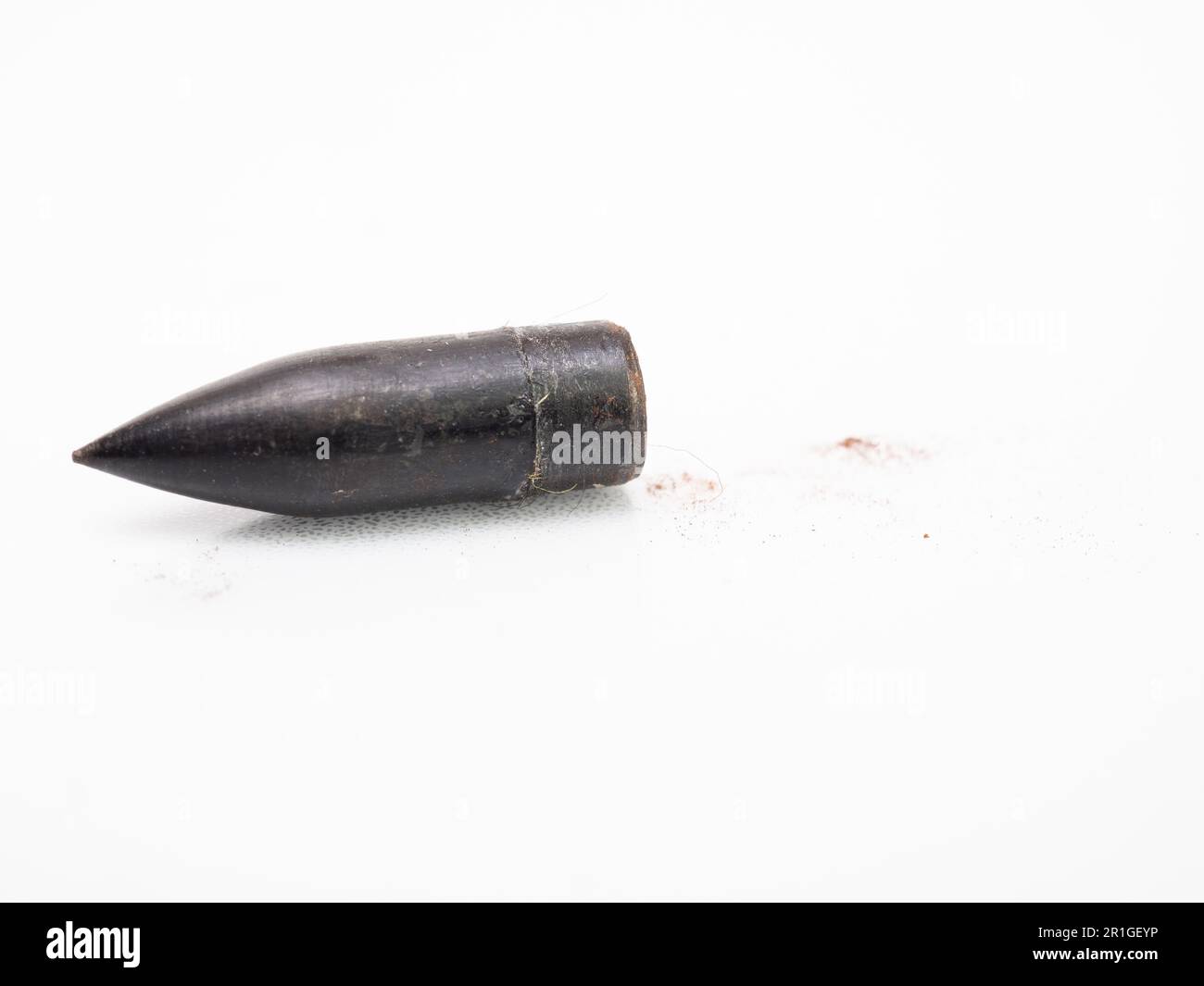 Picture of a black projectile on a white background with some gun ...