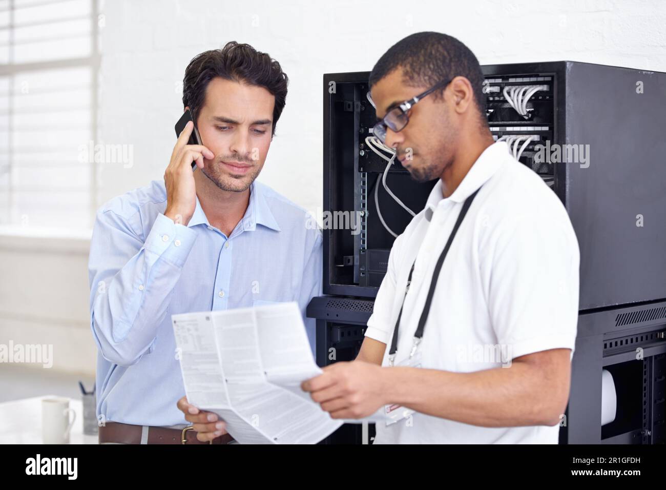 Server room, it support and phone call with a man technician reading ...