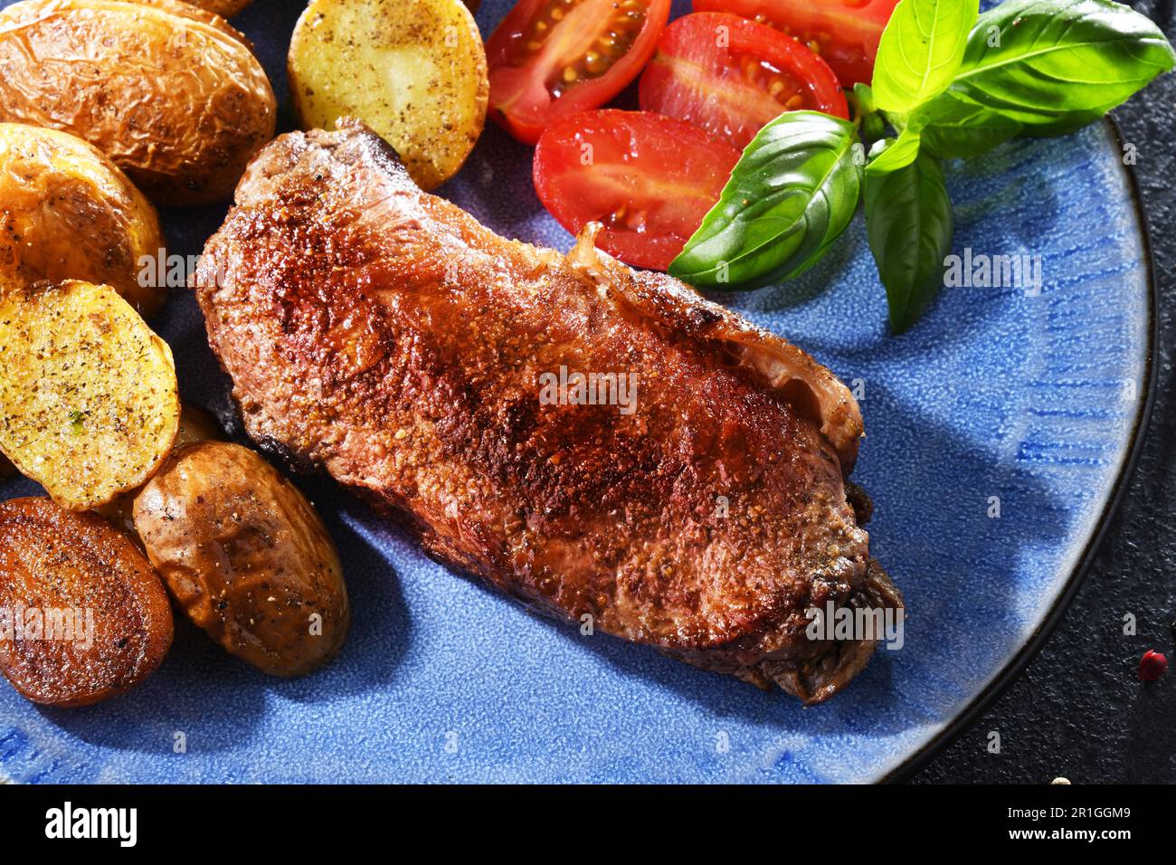 Pan-fried beef steak with fried potatoes and cherry tomatoes Stock ...