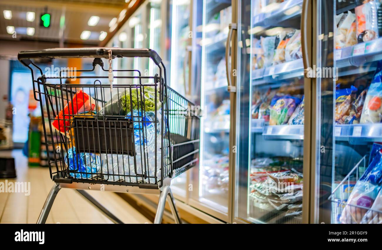 A shopping cart with grocery products in a supermarket Stock Photo - Alamy