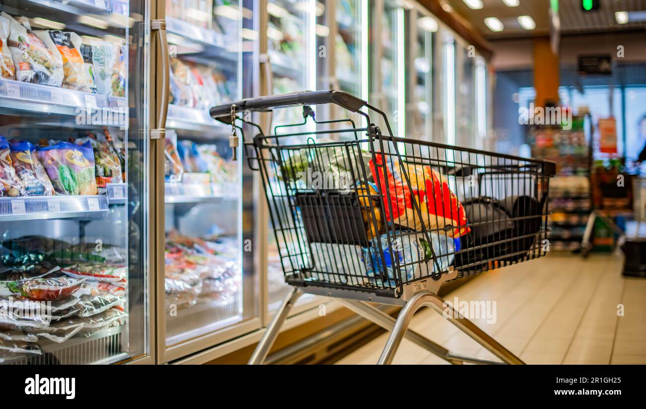 A shopping cart with grocery products in a supermarket Stock Photo - Alamy