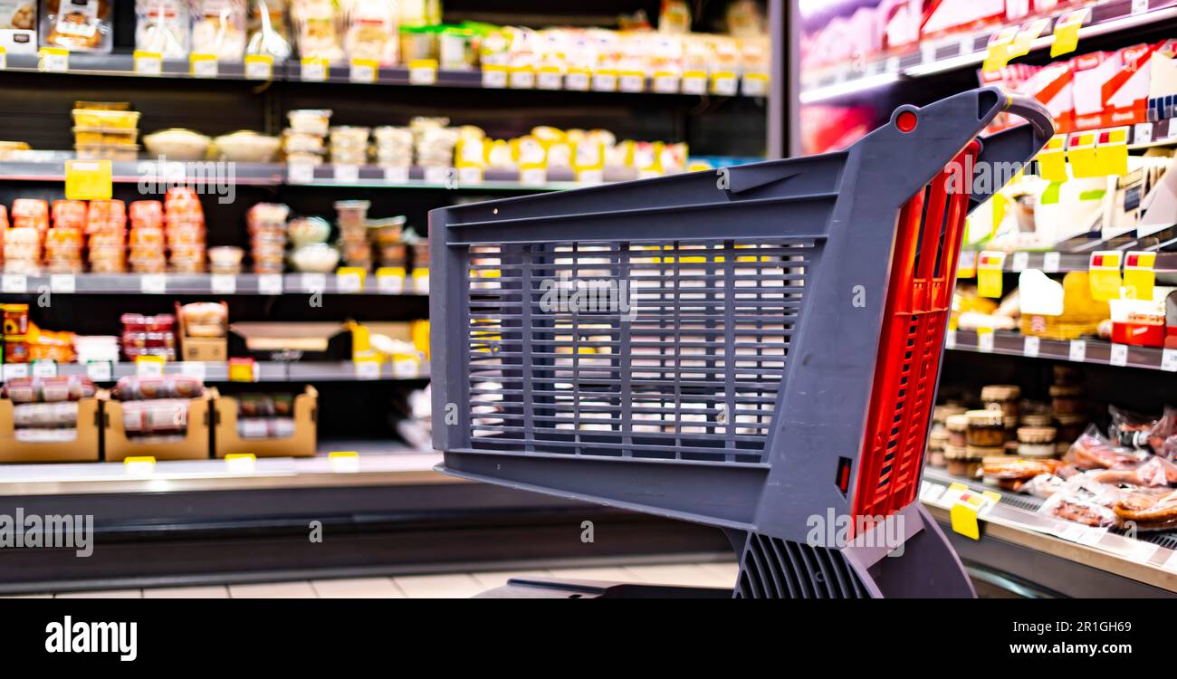 A shopping cart by a store shelf in a supermarket Stock Photo - Alamy