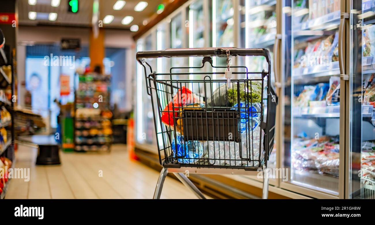 A shopping cart with grocery products in a supermarket Stock Photo - Alamy