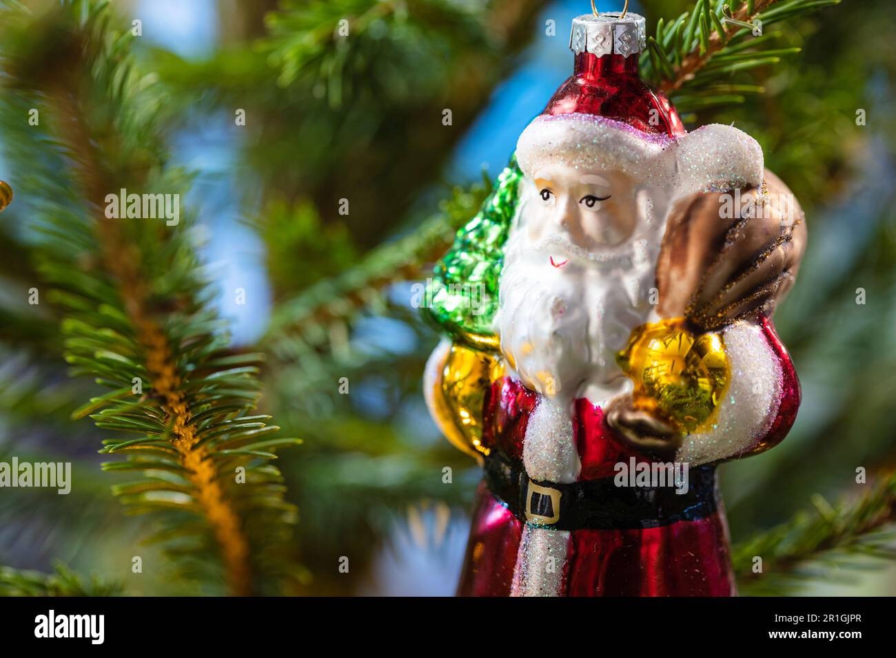 glass santa claus figurine on natural christmas tree close up indoor ...