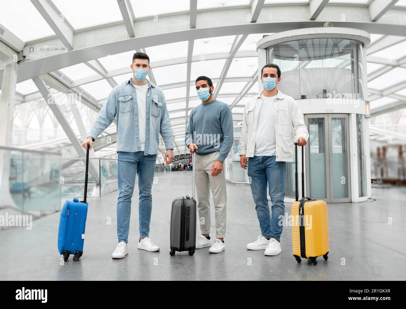Three Travelers Men Wearing Face Masks For Protection In Airport Stock ...