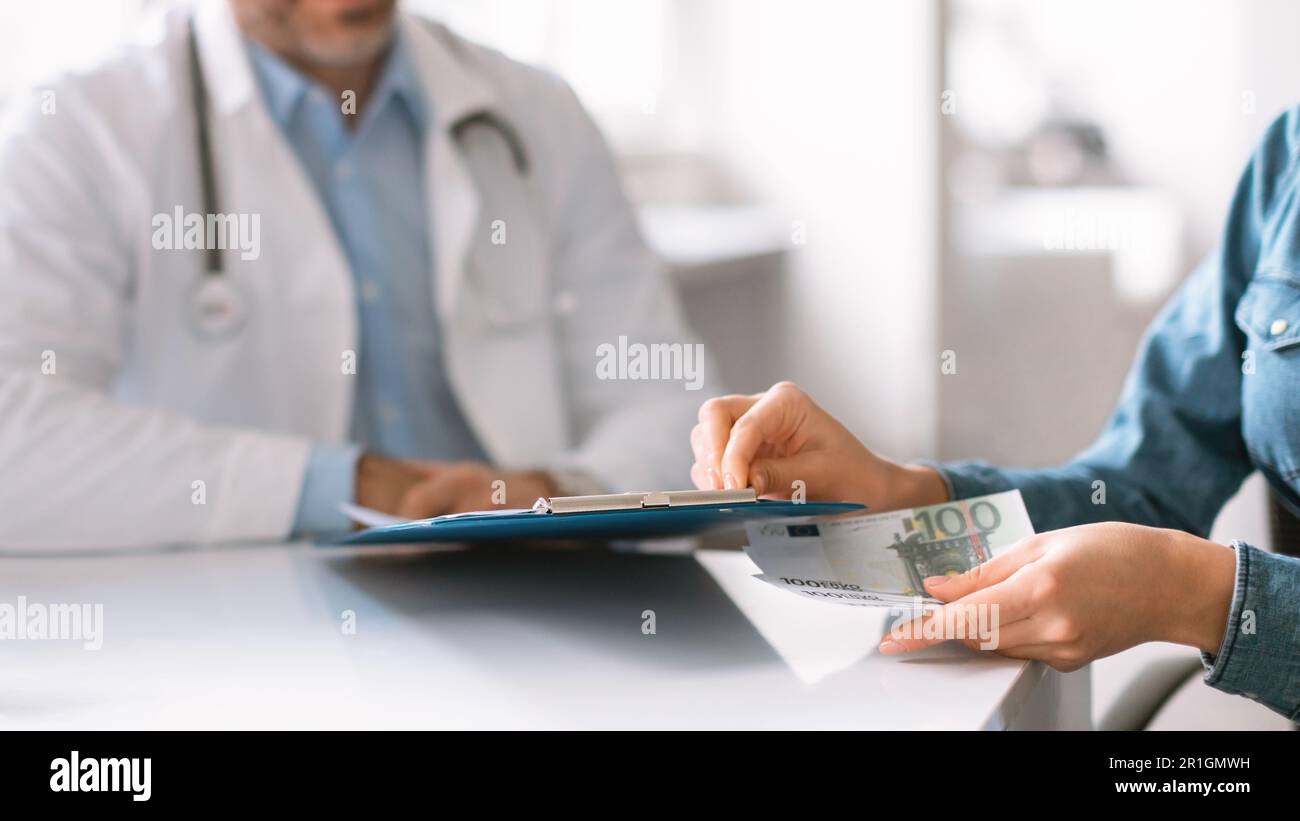 Healthcare sector corruption concept. Patient hand putting money dollar ...