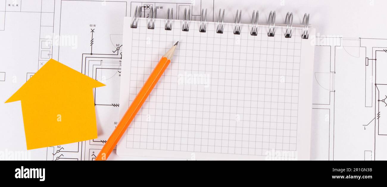 Notepad with pencil for writing notes and home shape on housing plan ...