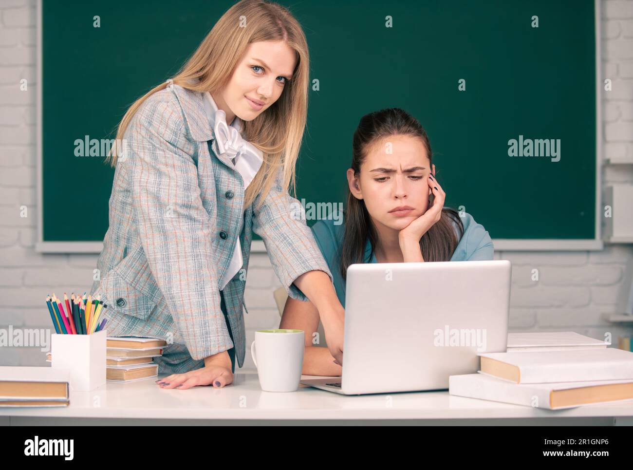 Students girls looking at laptop computer in classroom at school ...