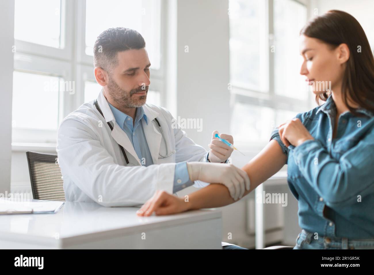 Protecting your health. Young woman getting vaccine shot against ...