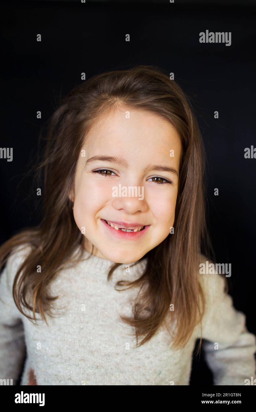 funny girl smiles without front baby teeth on a dark background Stock ...