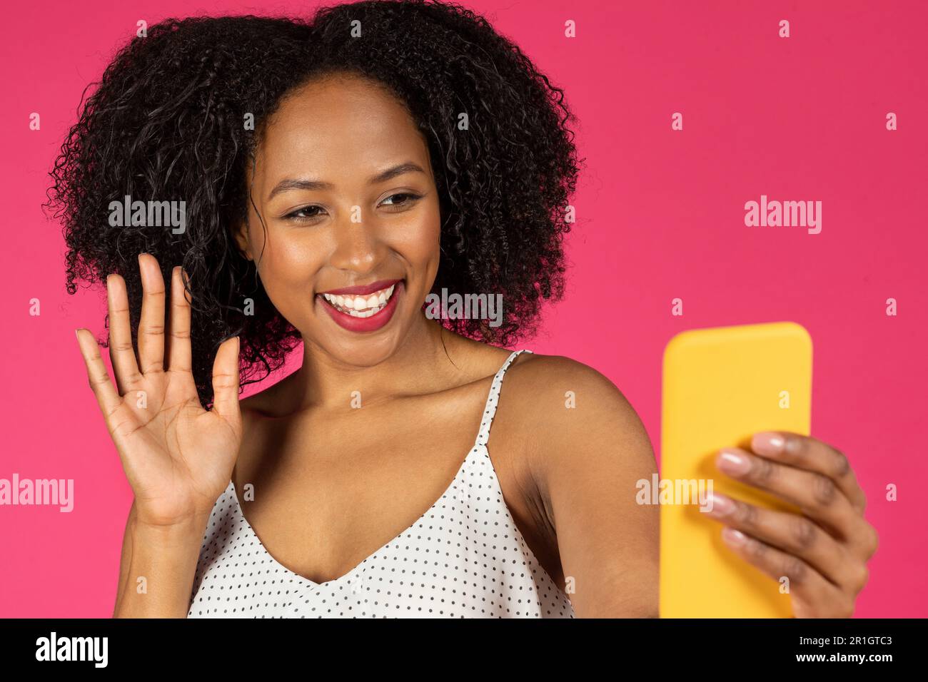 Happy millennial african american curly lady waving hand in smartphone ...