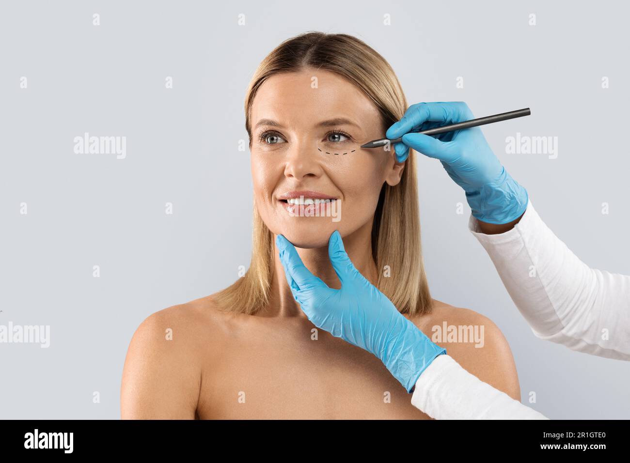 Beautician hands drawing contours on woman face before beauty treatment ...