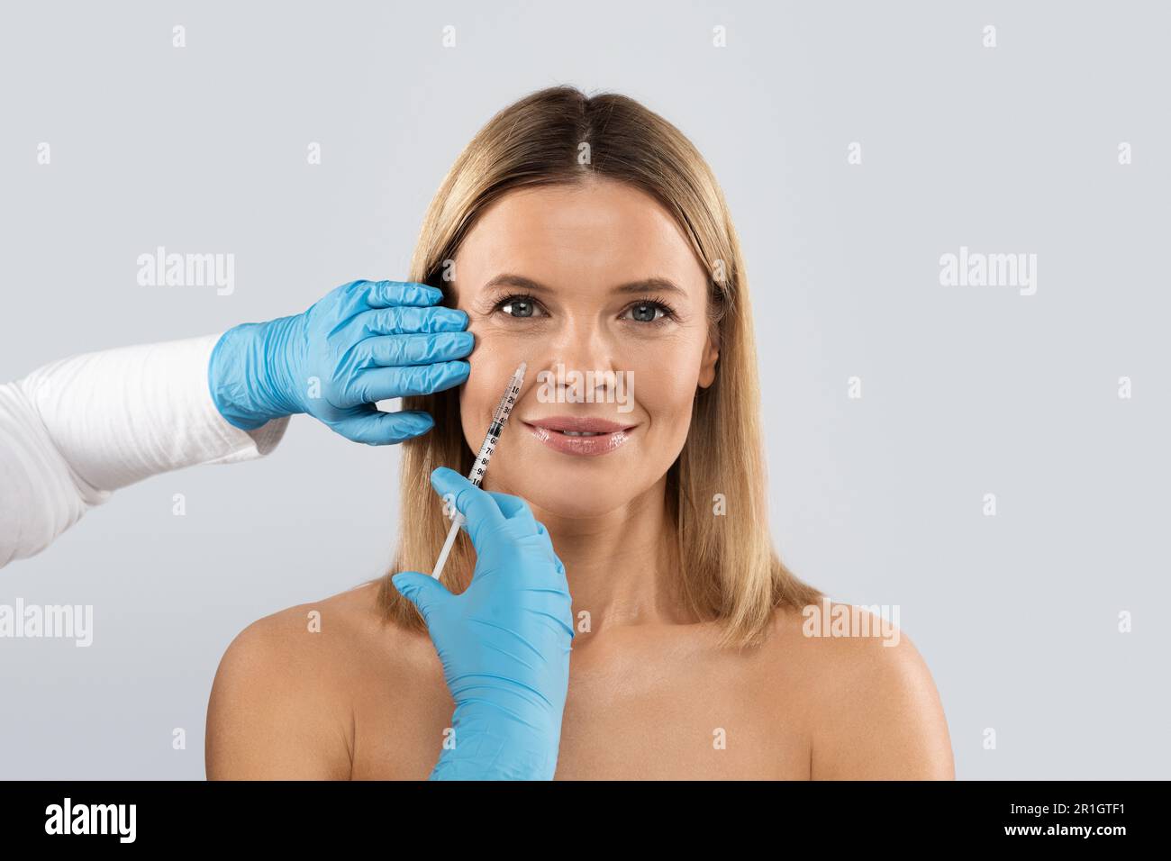 Middle aged woman getting under-eye filler injection Stock Photo - Alamy