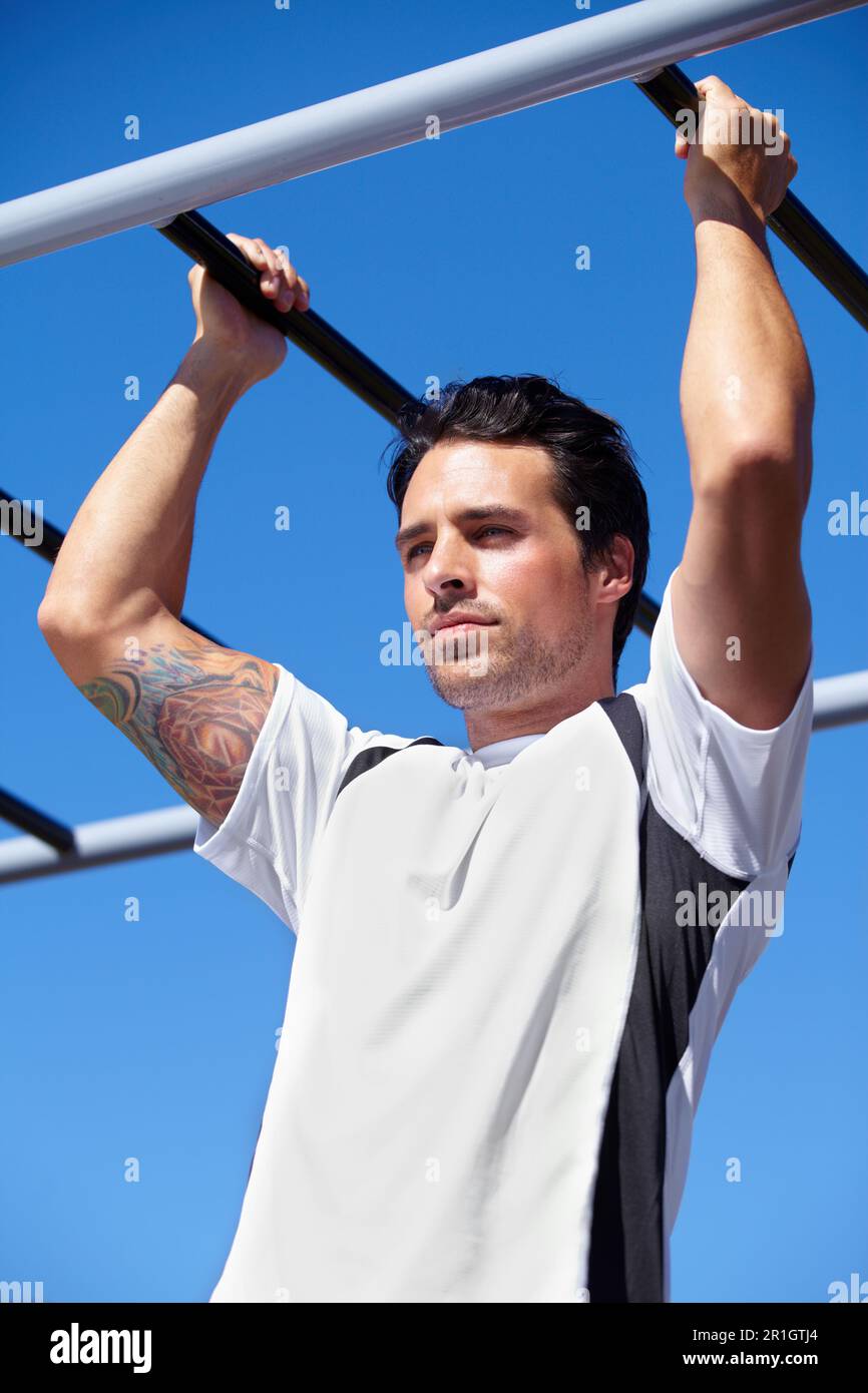 Man, fitness and pull ups on monkey bars in nature, park or outdoor gym ...