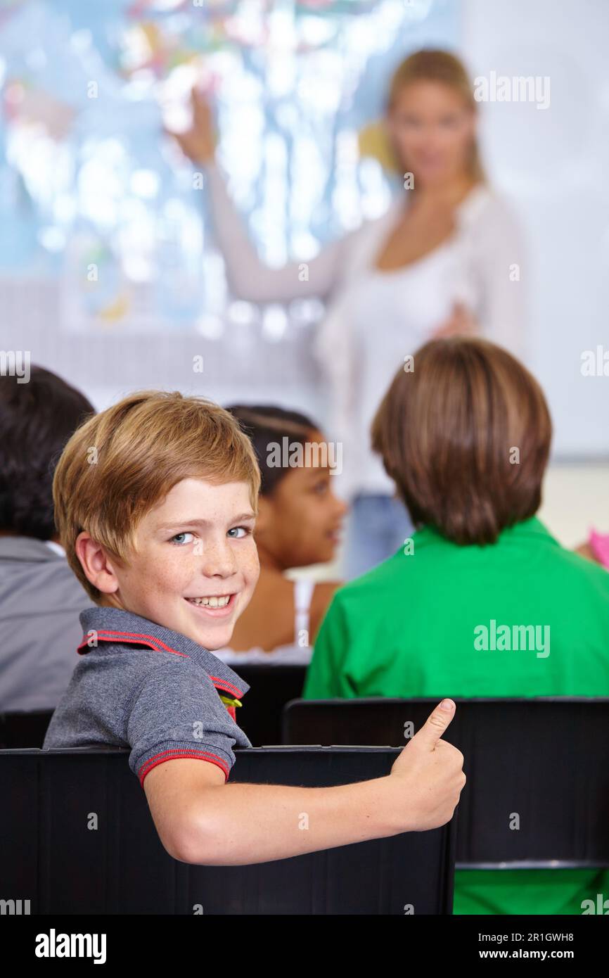 Child, portrait and thumbs up of student in classroom, elementary ...