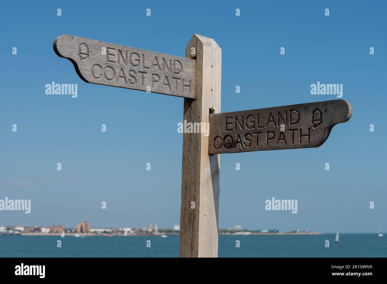 England coast path sign in Hampshire, England with the coastline of ...