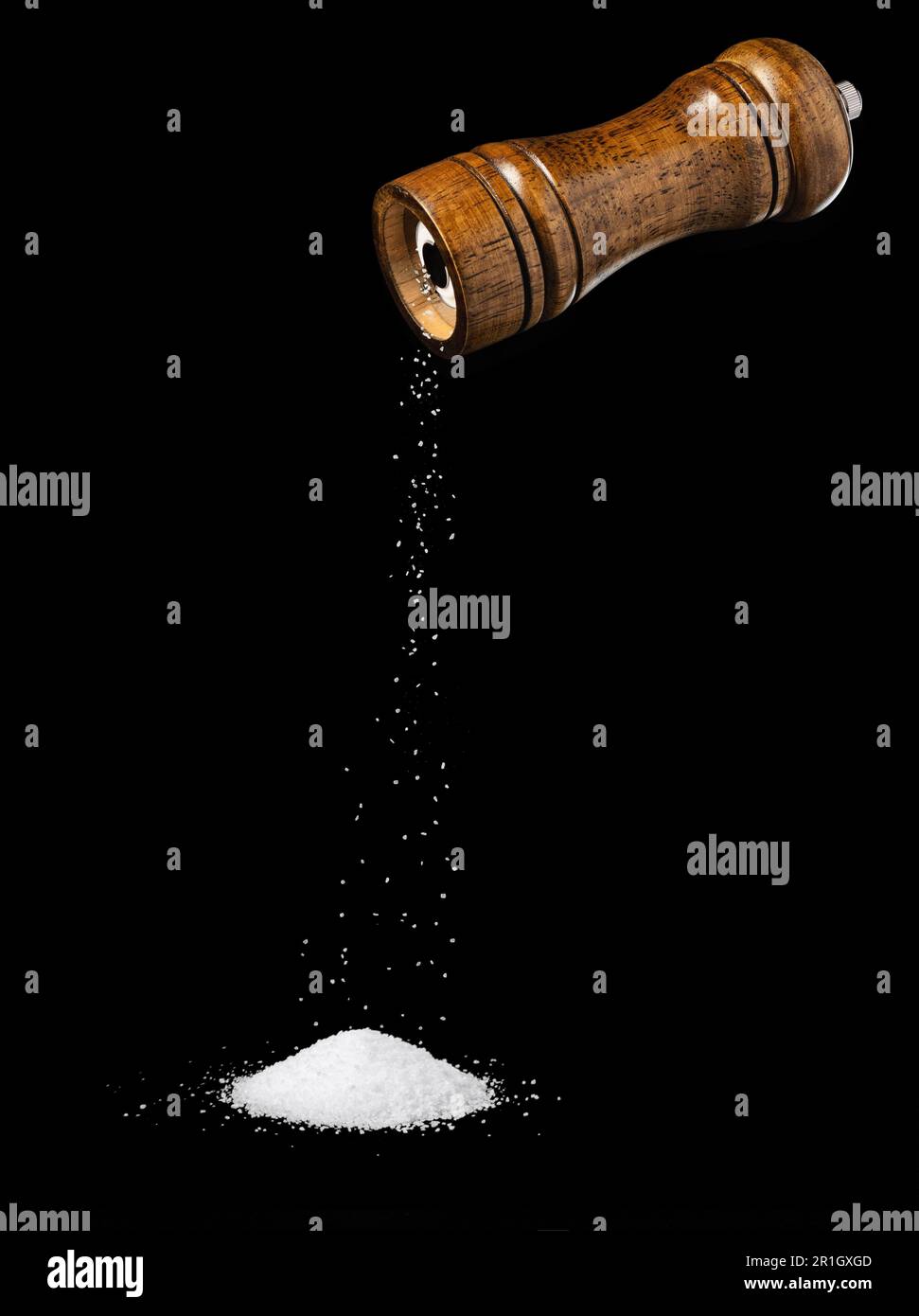 Salt falling from wooden grinder isolated on black Stock Photo - Alamy