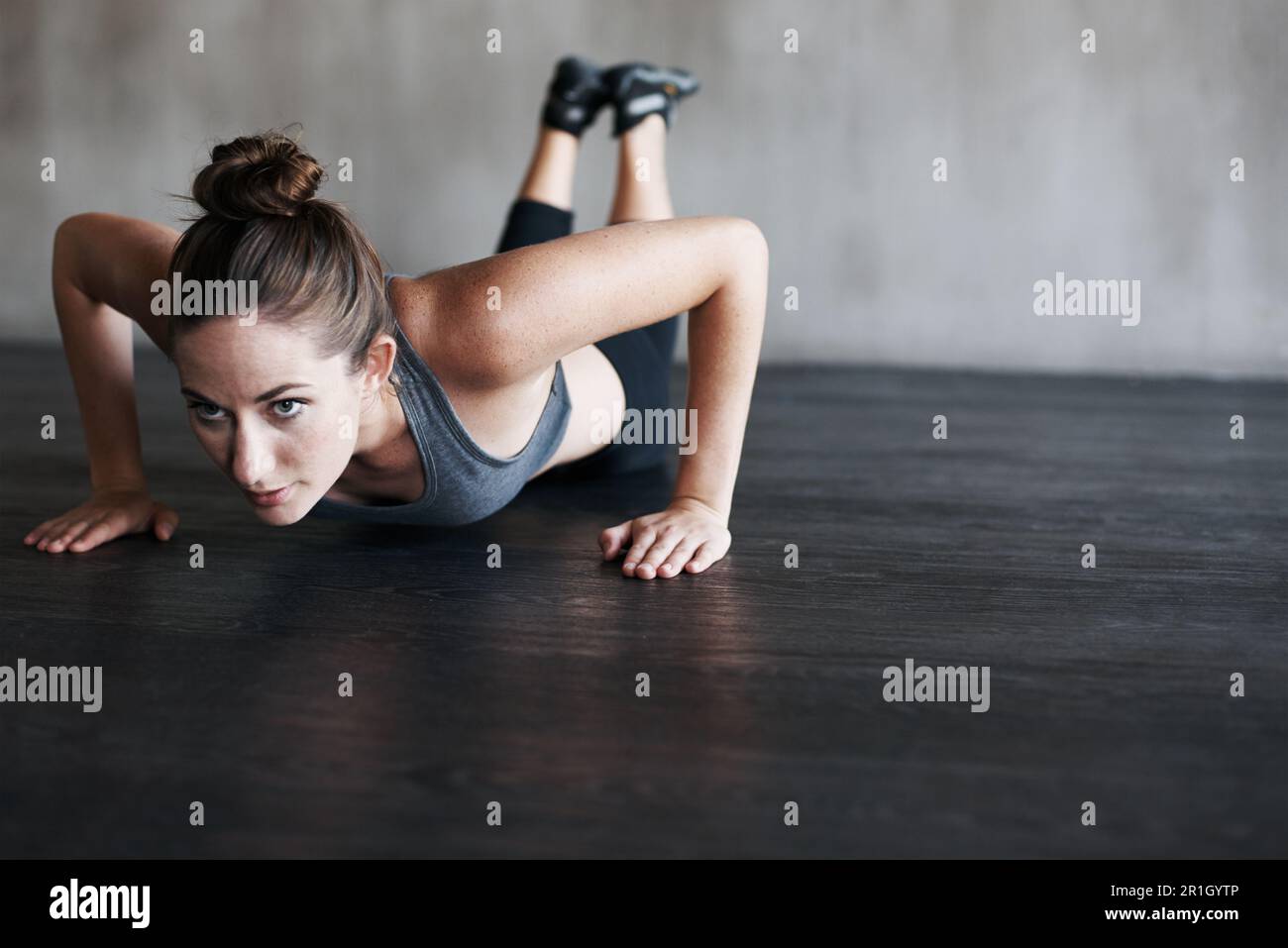 Workout, endurance focus and woman doing push up for strength exercise, gym commitment or muscle ...