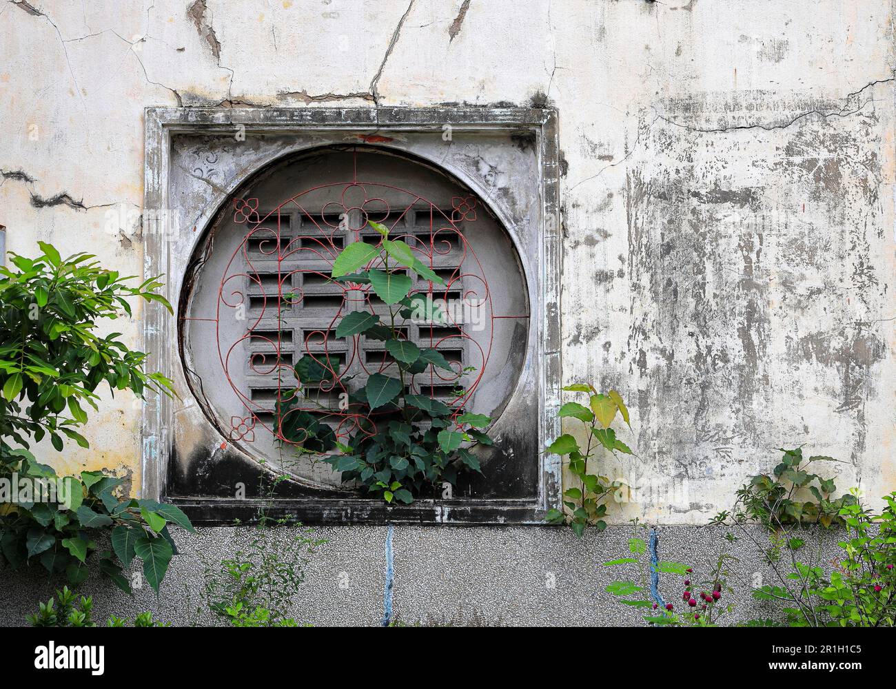 circle window packed with concrete block wall on old Abandoned building ...
