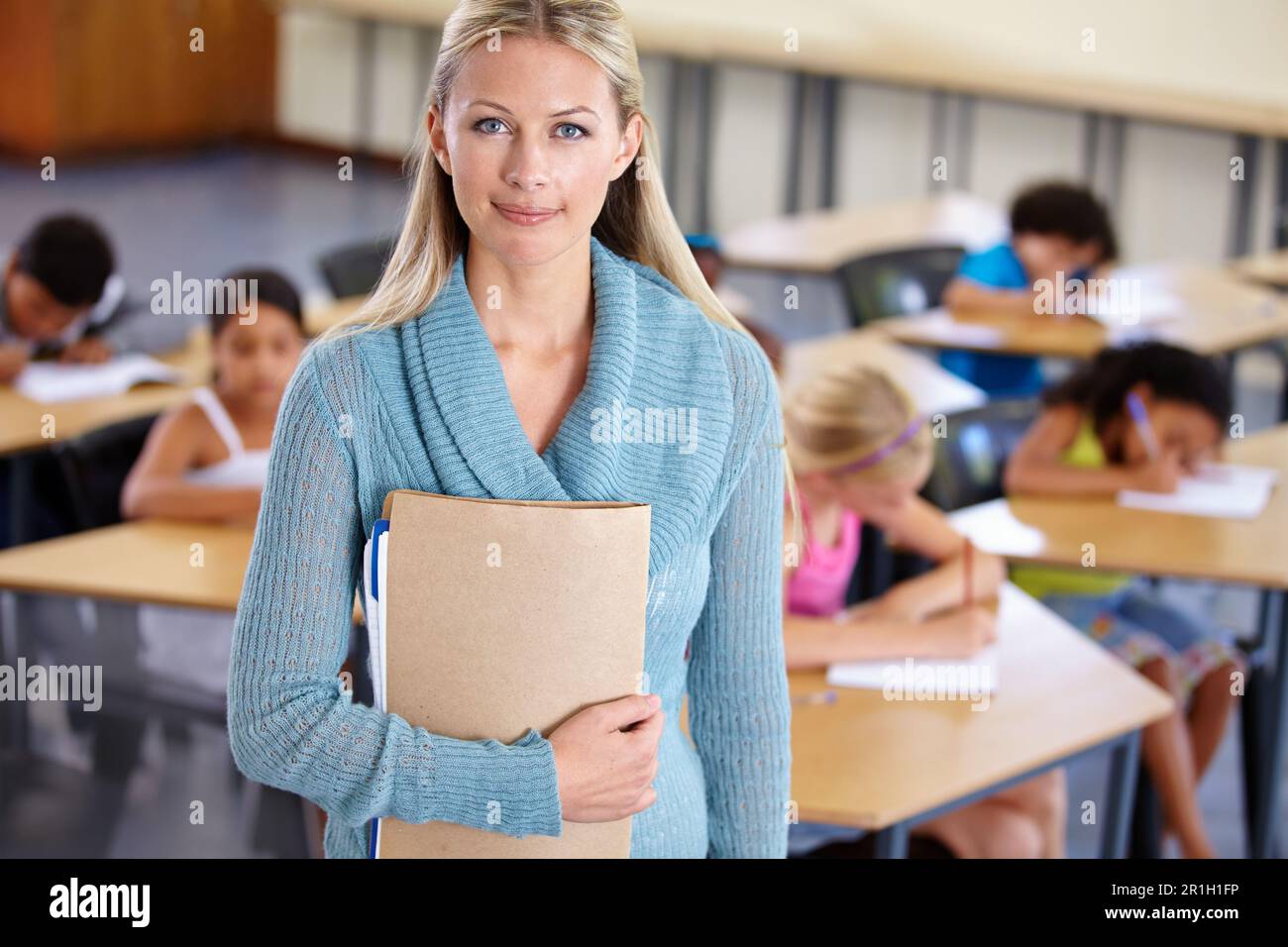 Teacher, portrait and woman with binder in classroom, elementary school ...