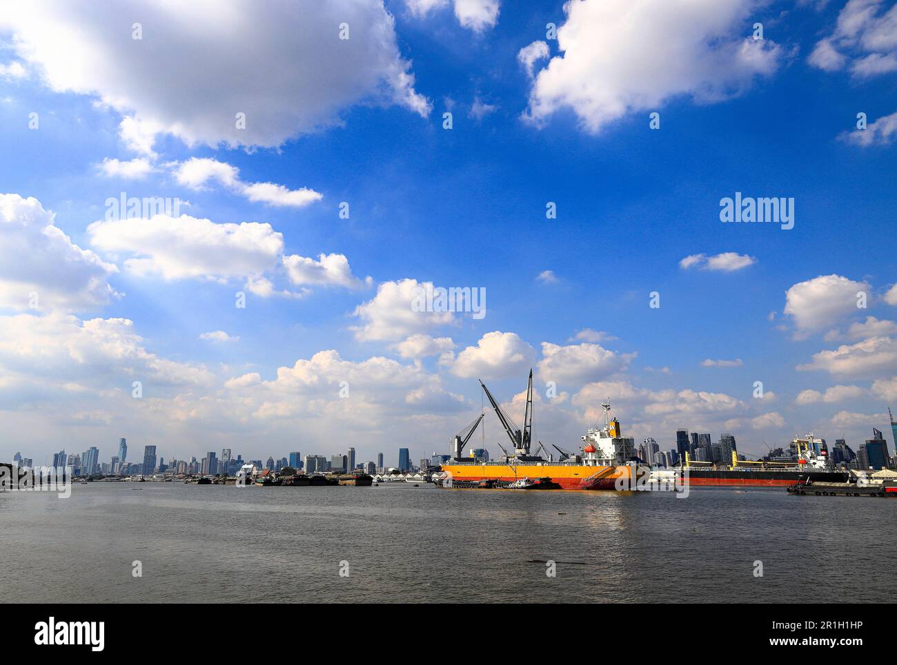cargo ship or Ocean barge with cranes at international port, with CBD ...